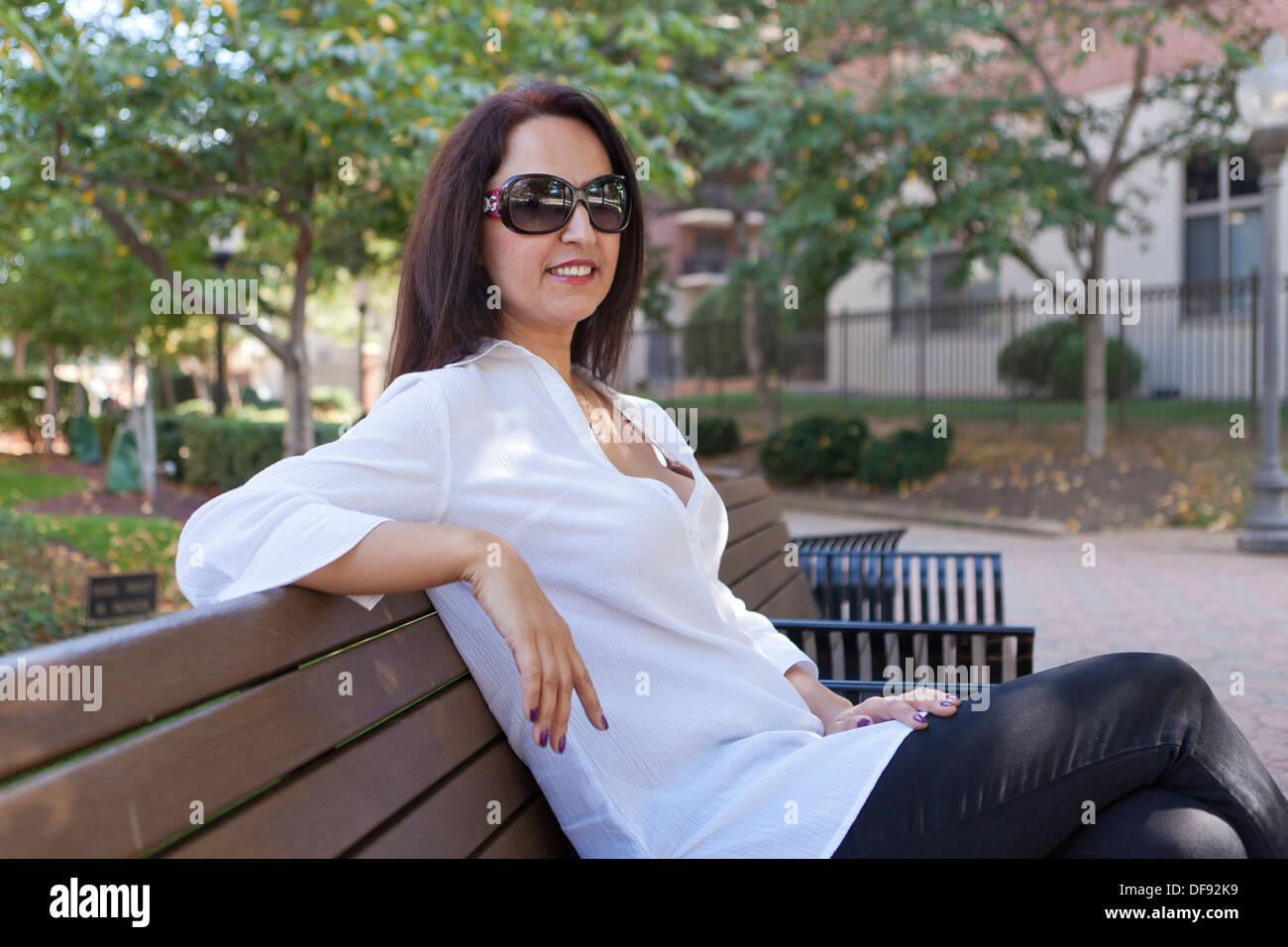 Woman sitting on bench Stock Photo - Alamy