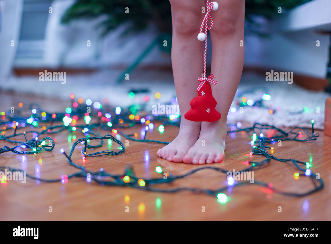 Little red tree in the hands of charming cute girl at bright lights ...