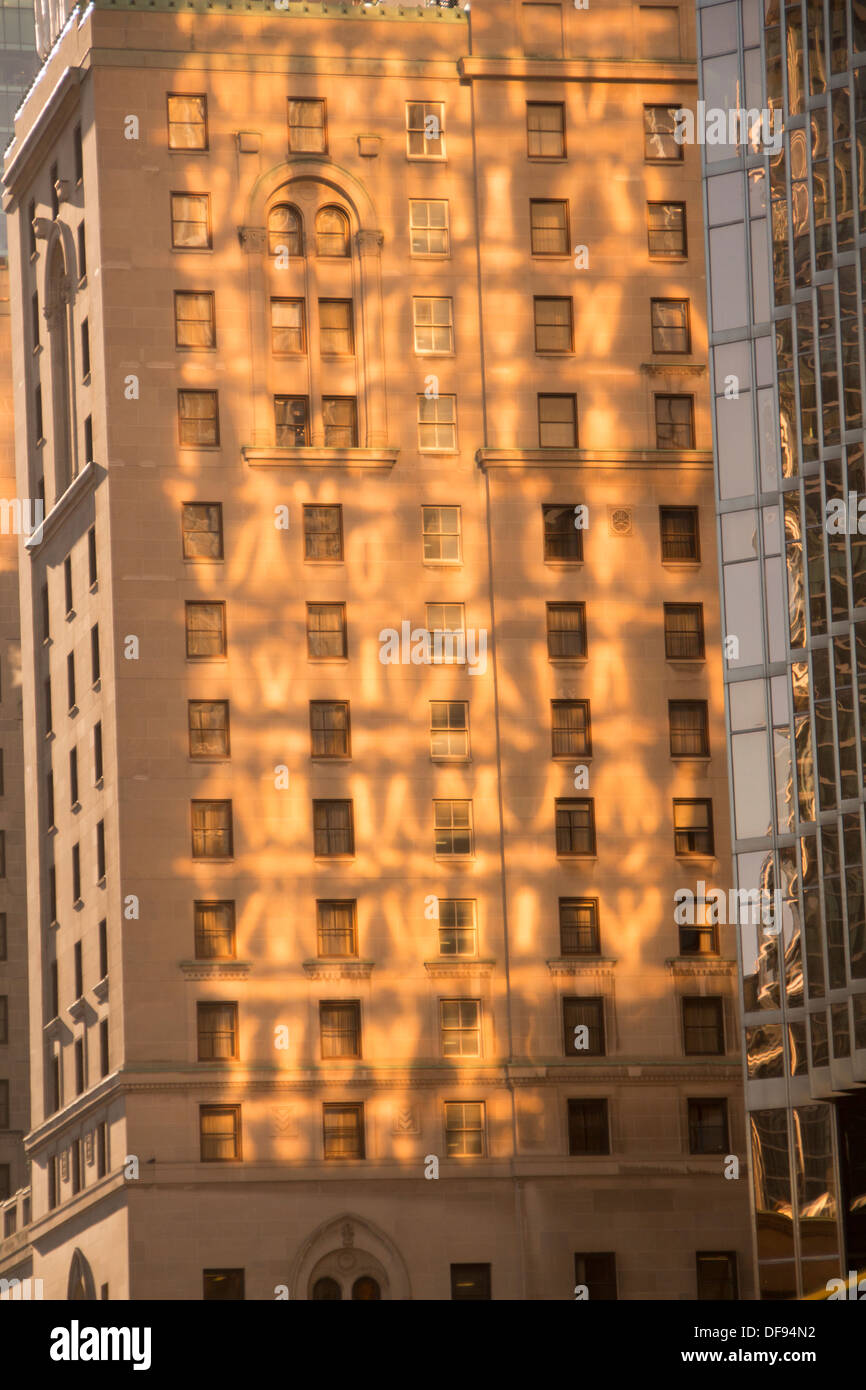 Late afternoon reflection of a glass building on a concrete building in ...