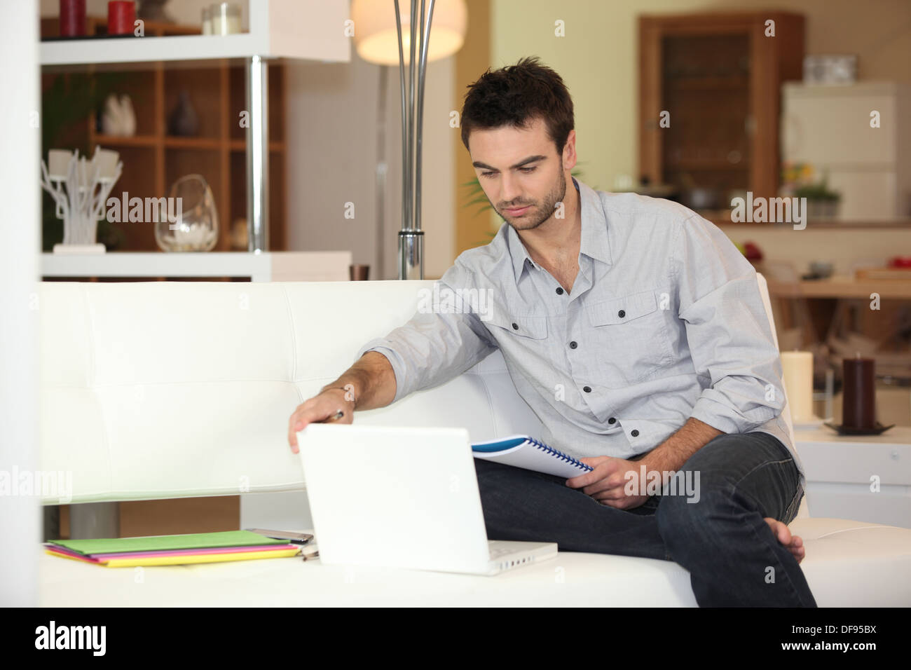 man sitting on the couch with a computer Stock Photo - Alamy
