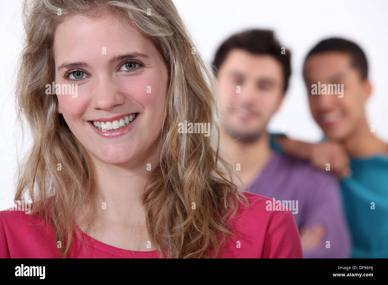 Smiling young woman with lads in the background Stock Photo - Alamy
