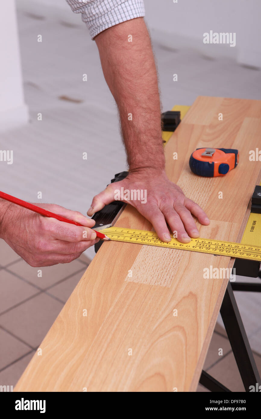 Man measuring plank Stock Photo - Alamy