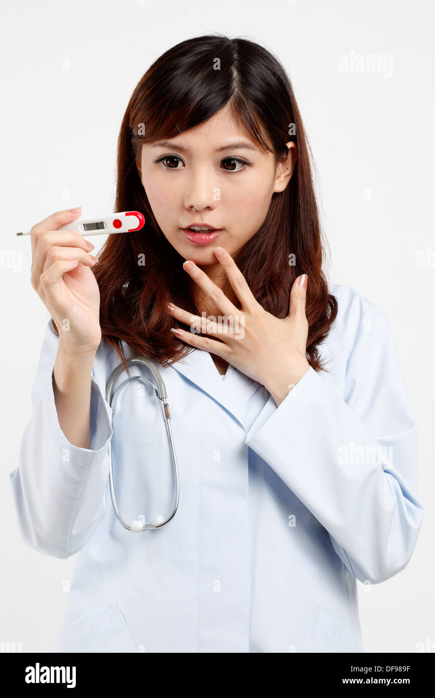 Female doctor looks at thermometer Stock Photo - Alamy