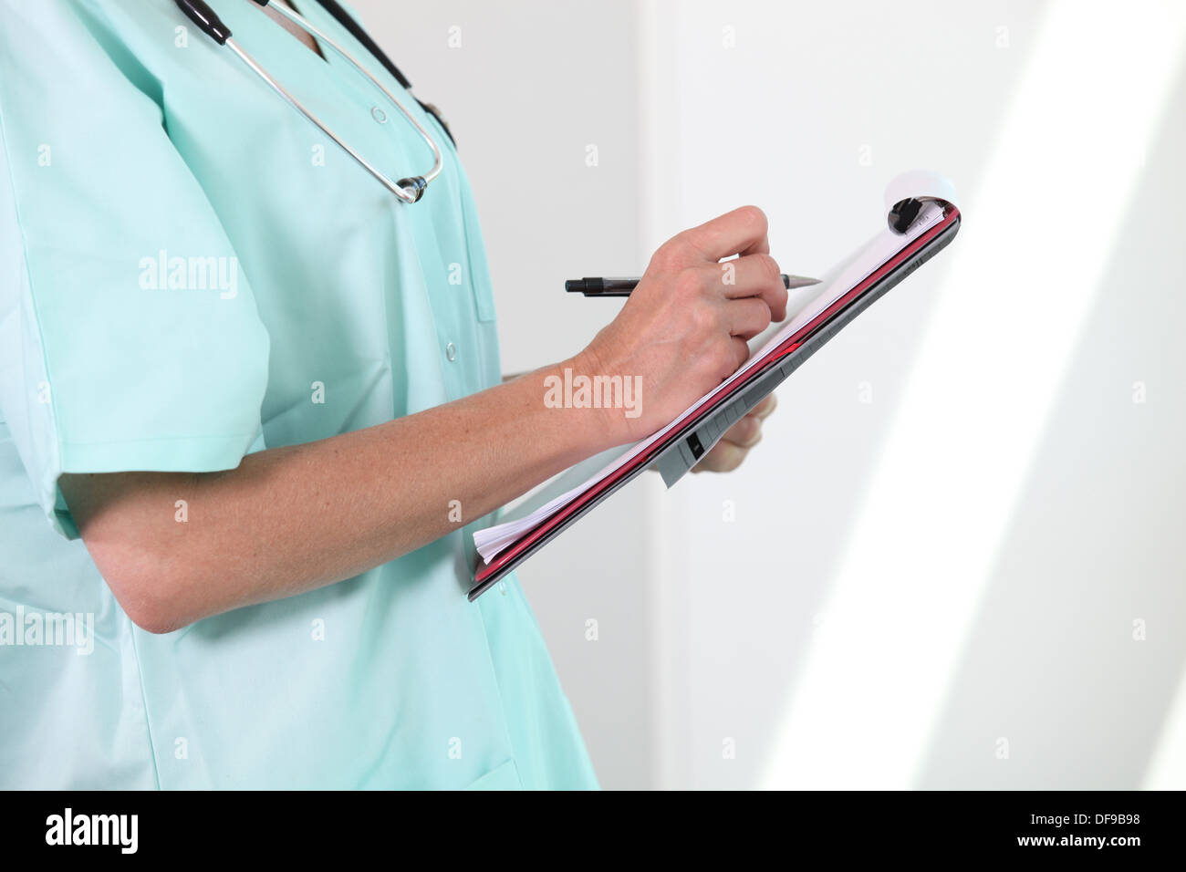 Medic writing notes on clipboard Stock Photo - Alamy