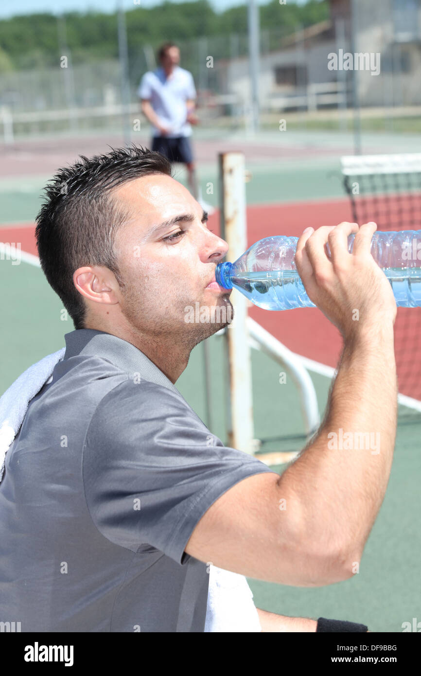 Tennis player drinking on the bench Stock Photo - Alamy