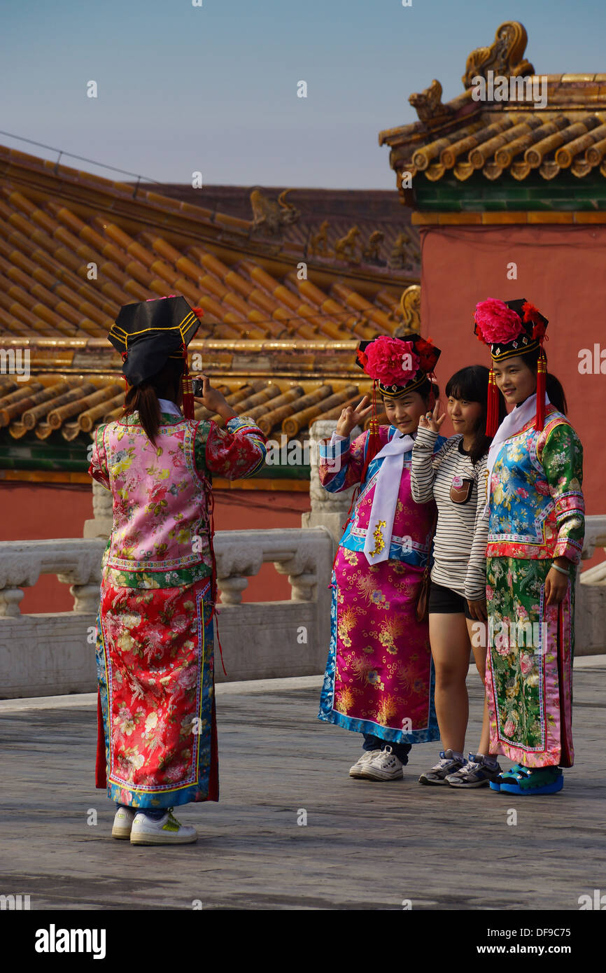Chinese girls on a day out in the Forbidden City, Beijing, try on ...