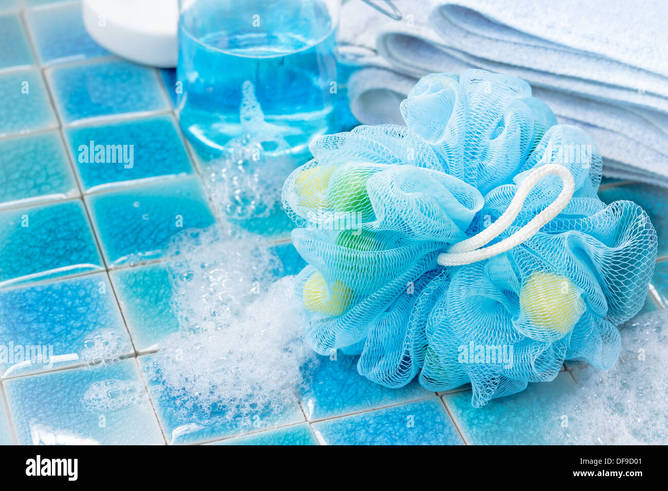 Soft blue bath puff or sponge on blue tile background Stock Photo - Alamy