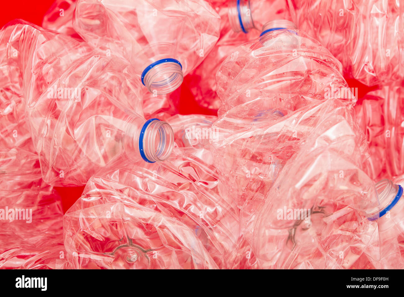 Squeezed bottles of mineral water with a red background Stock Photo - Alamy