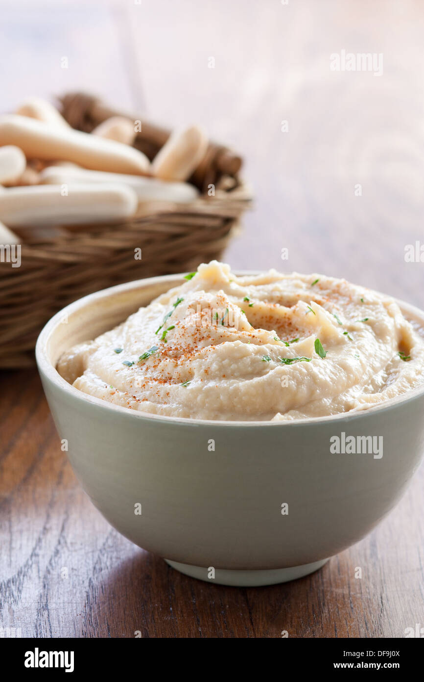 Delicious bowl of chickpea hummus with breadsticks Stock Photo - Alamy