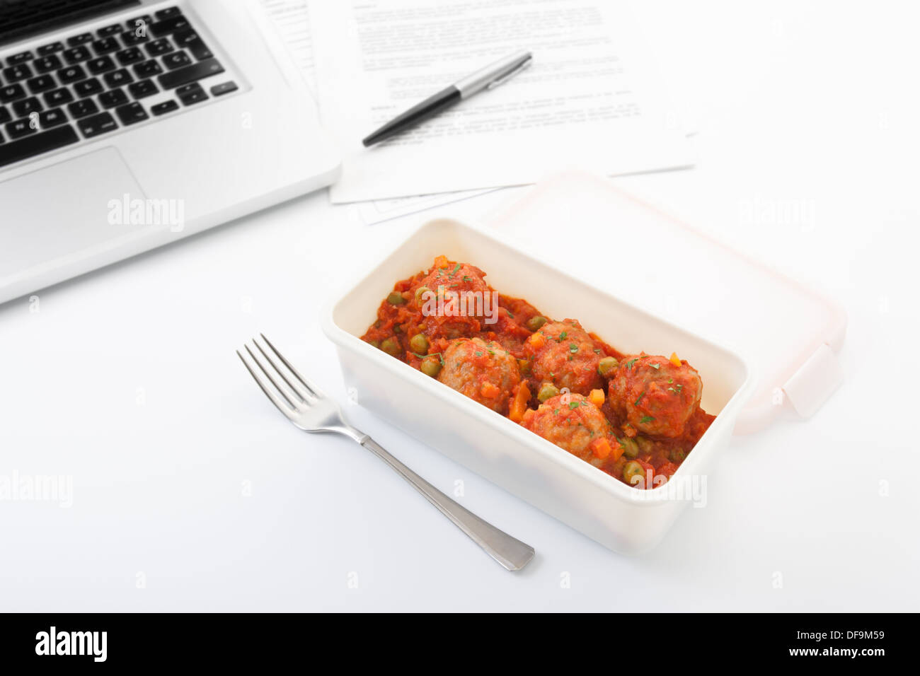 Eating meatballs with tomato and peas in the office Stock Photo - Alamy