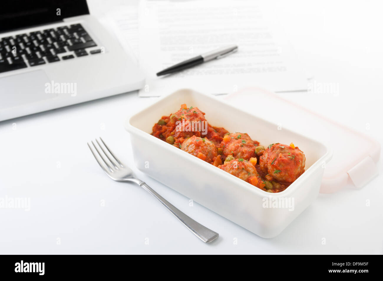 Eating meatballs with tomato and peas in the office Stock Photo - Alamy
