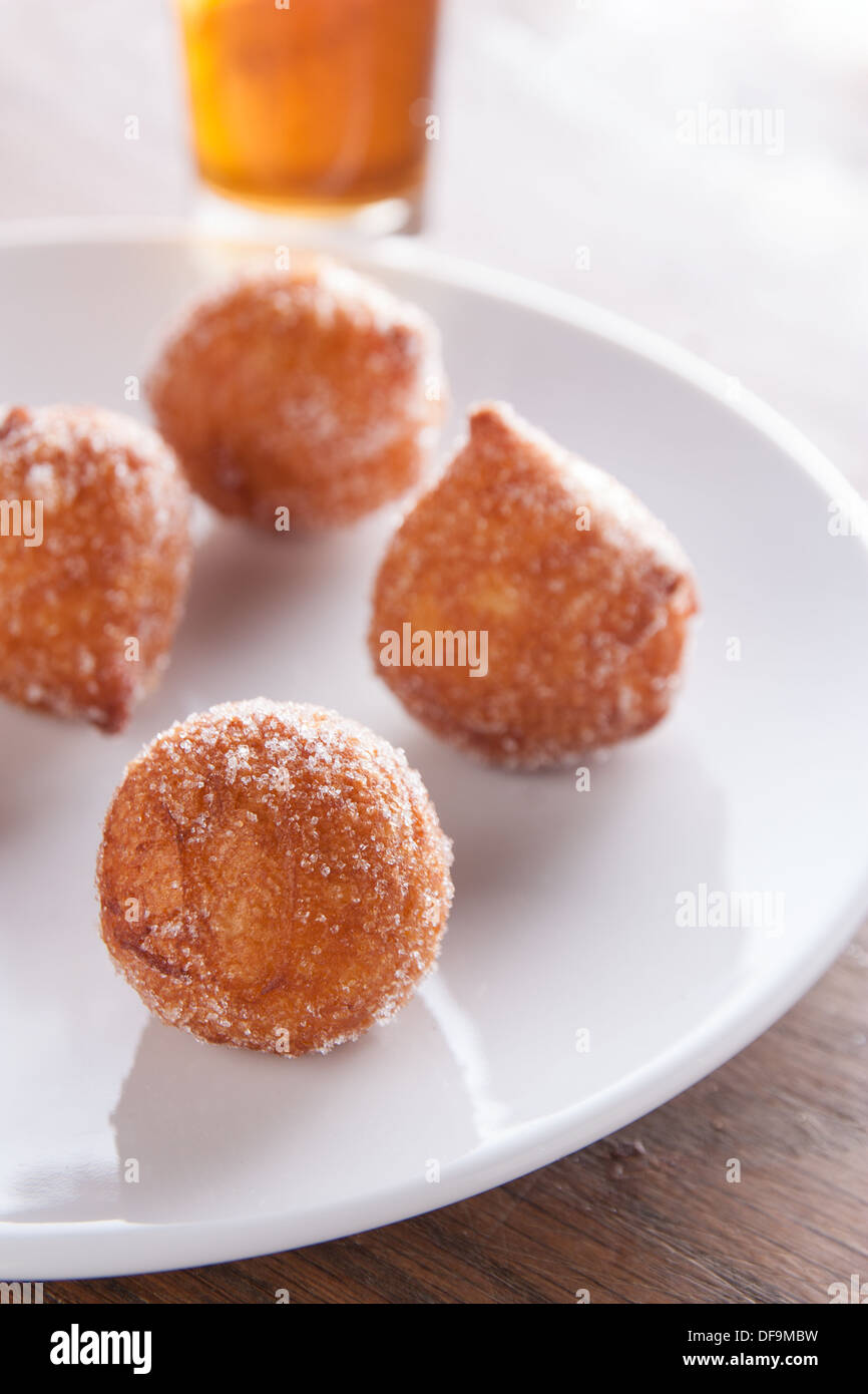 Traditional fritter puff dusted with sugar on a dish Stock Photo - Alamy