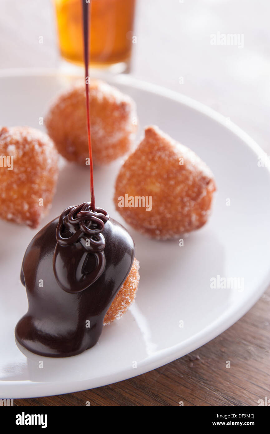 Fritter puff dusted with sugar and chocolate sauce Stock Photo - Alamy