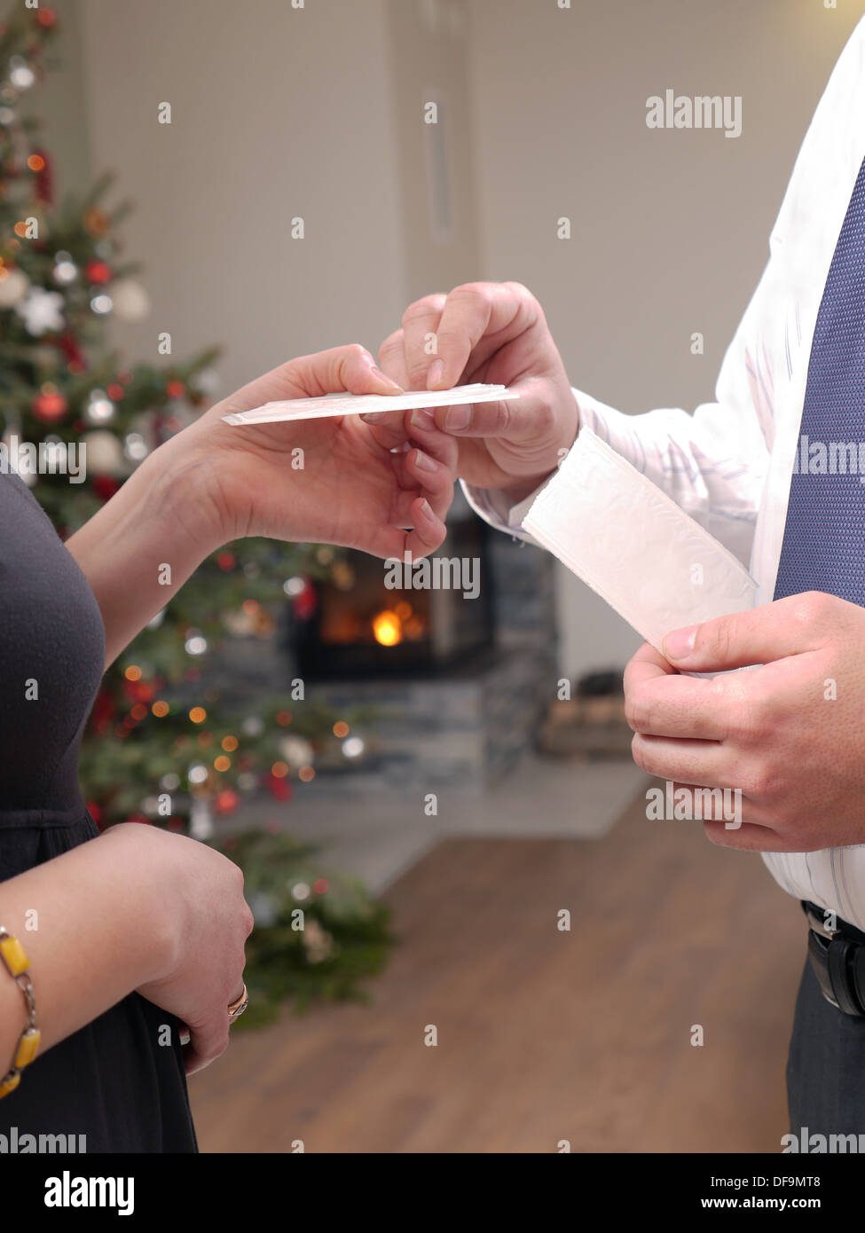 Closeup of young couple hands sharing traditional Christmas Eve wafer ...