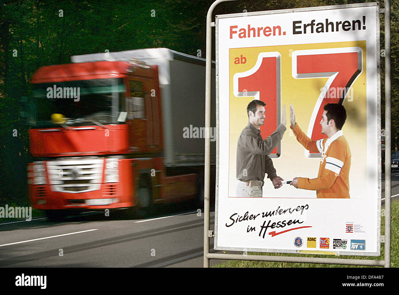A truck drives past a sign promoting the driver's licence with 17 on ...