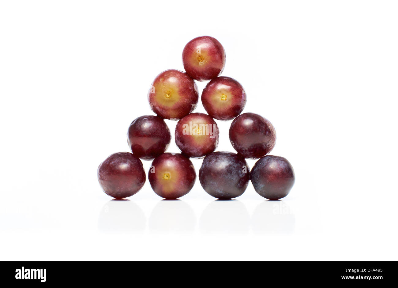 A pyramid of red grapes on a white background Stock Photo - Alamy