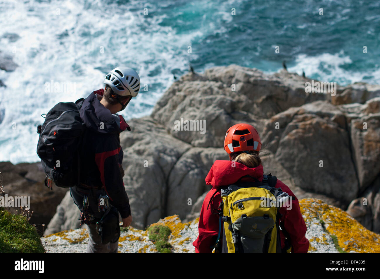 Two climbers looking at a seacliff route on Lundy Island Stock Photo ...