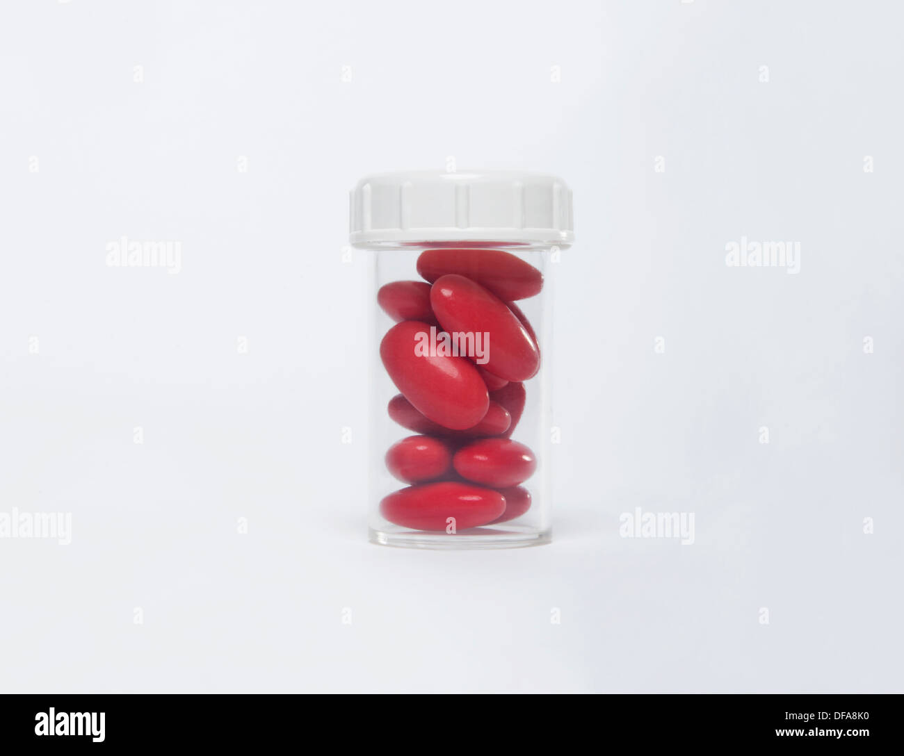 Red capsules in transparent bottle on a white background Stock Photo ...