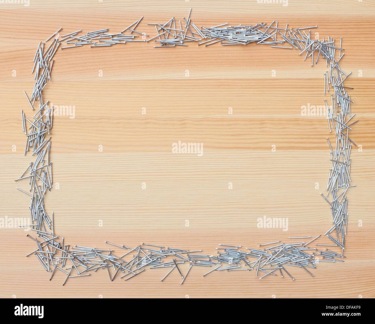 Shiny metal panel pins as a DIY themed rectangular border on wood ...