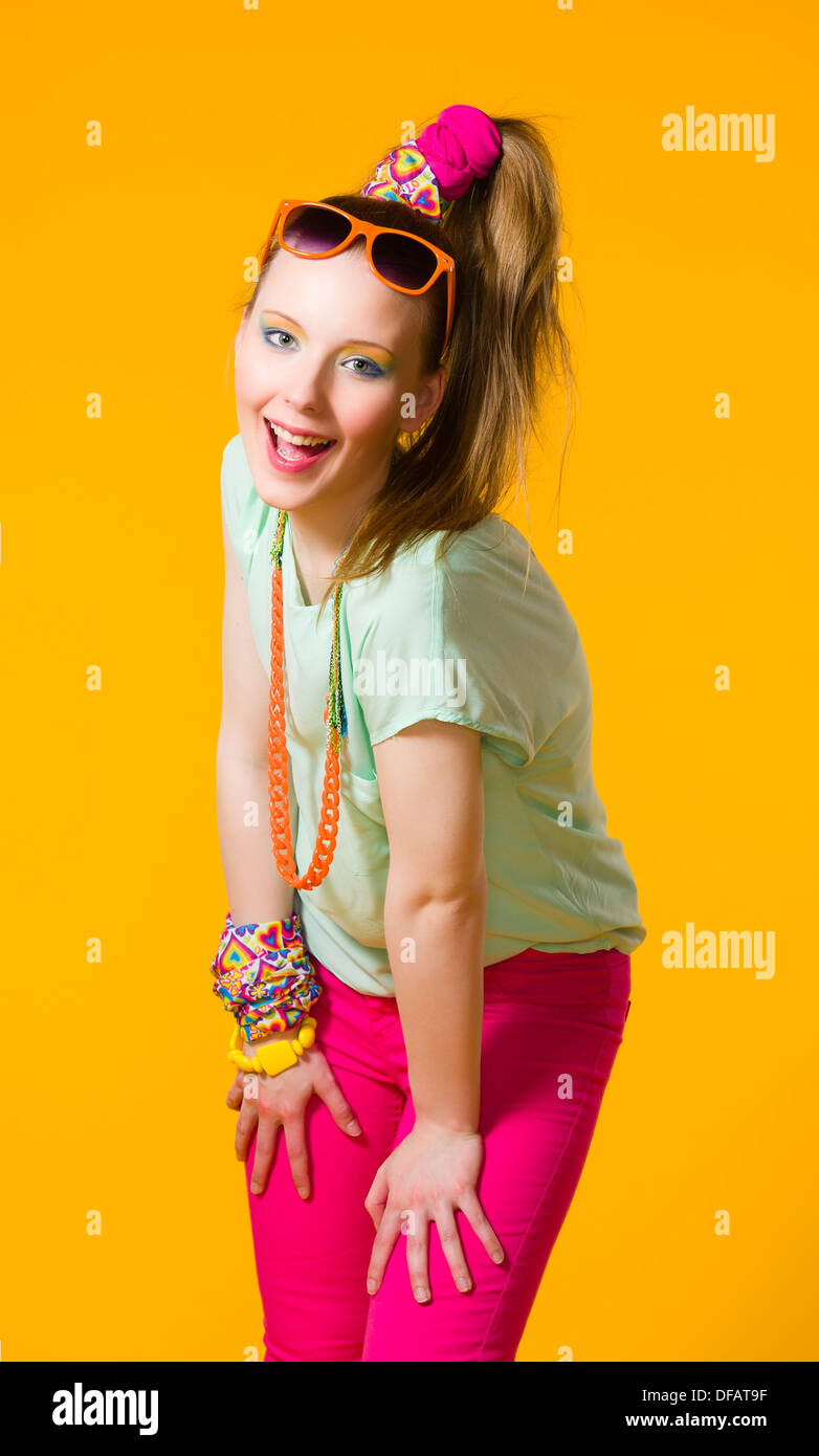 Happy girl with colorful clothes, yellow background Stock Photo - Alamy