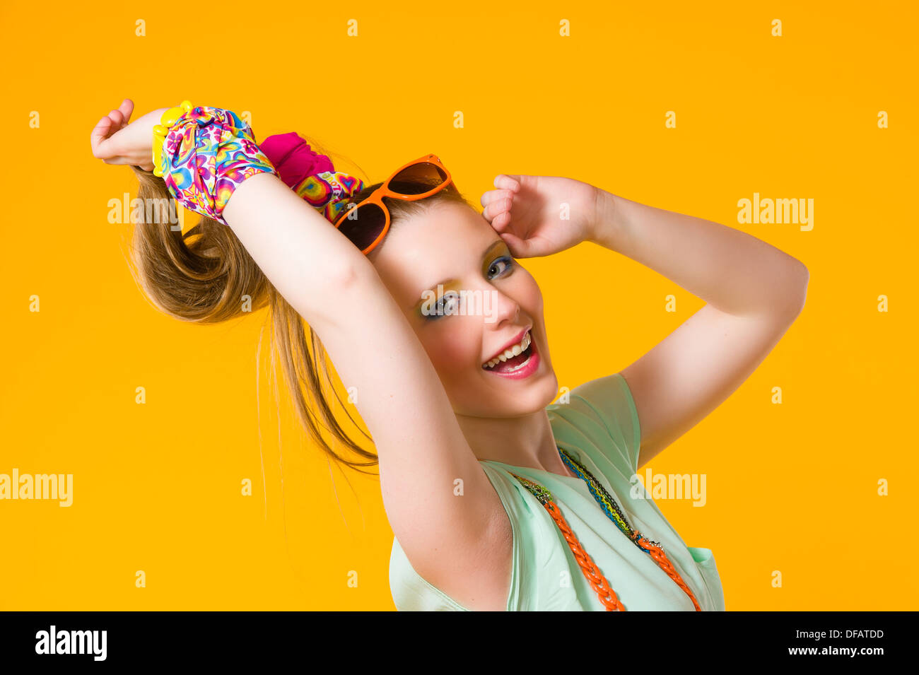 Happy girl with colorful clothes, yellow background Stock Photo - Alamy