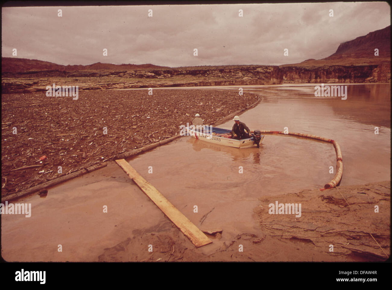 A boat pushes oil-laden debris as part of an oil spill clean-up ...