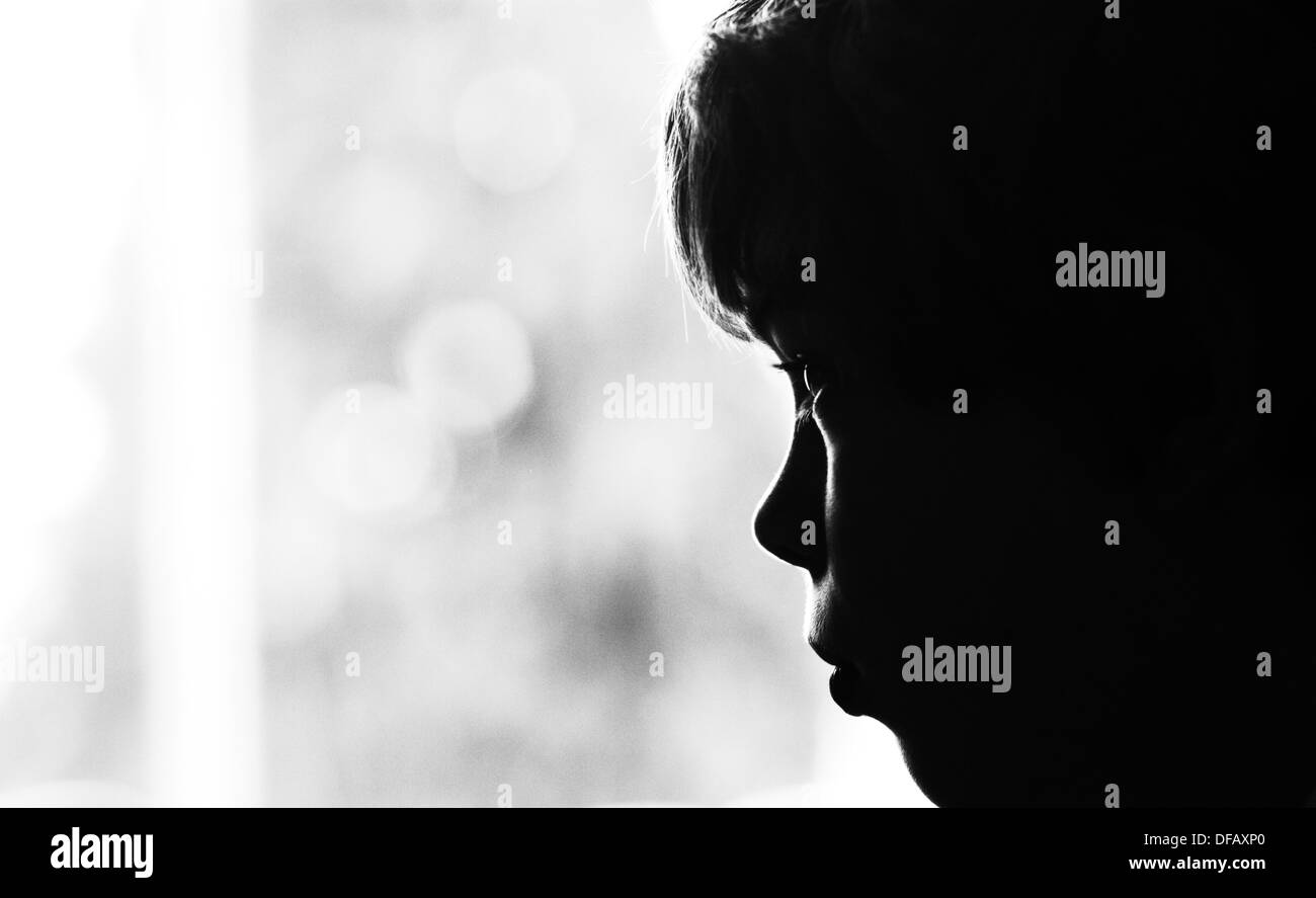 Boys face silhouetted against back light Stock Photo - Alamy