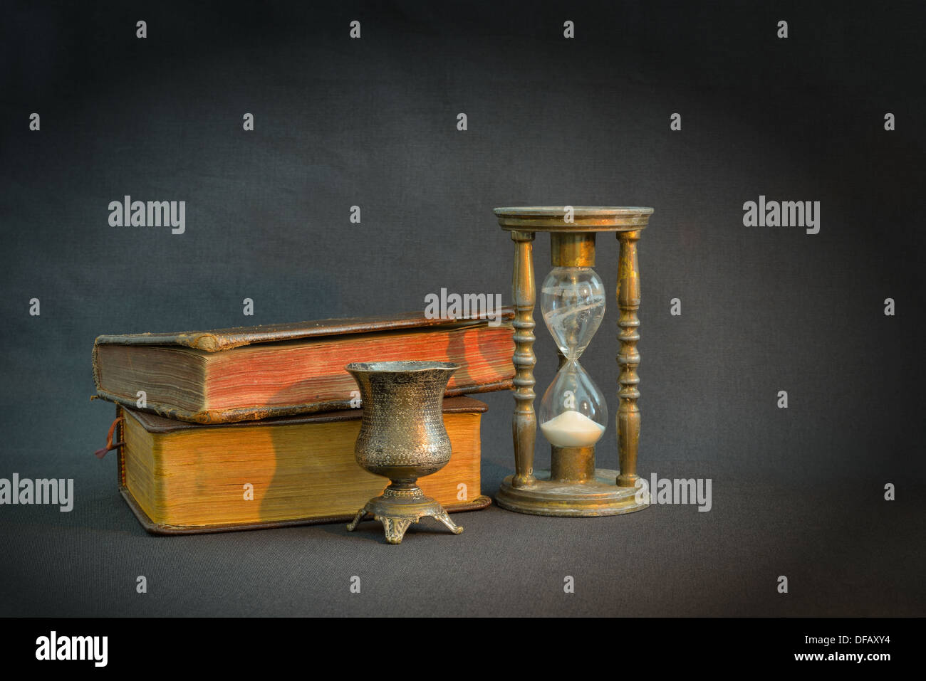 Vintage books and hourglass in dark room Stock Photo - Alamy