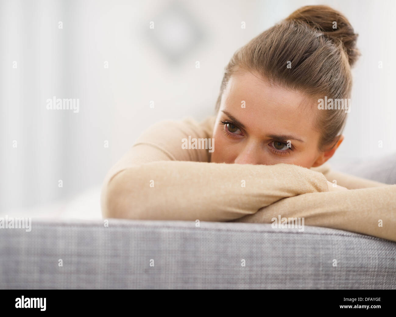 Stressed young woman sitting on sofa Stock Photo - Alamy