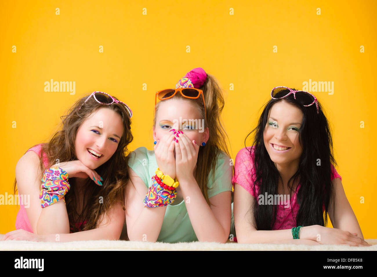 Three girls are having fun together, yellow background Stock Photo - Alamy