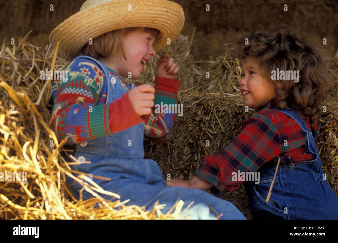 two ranch kids in a barn playing Stock Photo - Alamy