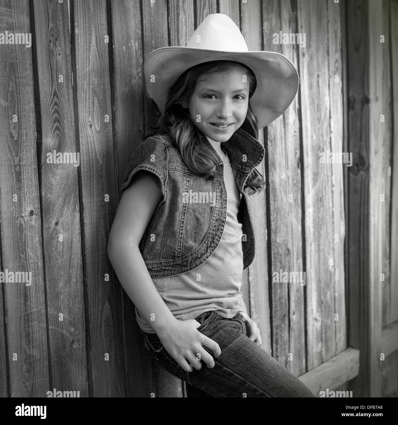Children girl as kid cowboy girl cowgirl posing on wooden fence far ...