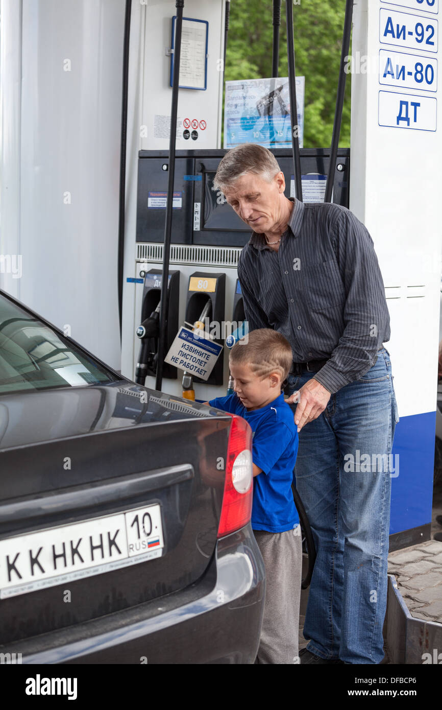 Little son helps to father while fueling the car with gasoline Stock ...
