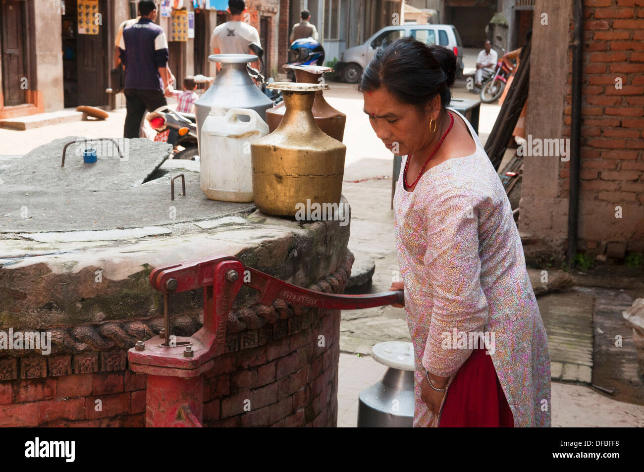 Woman getting water at communal tap hi-res stock photography and images ...