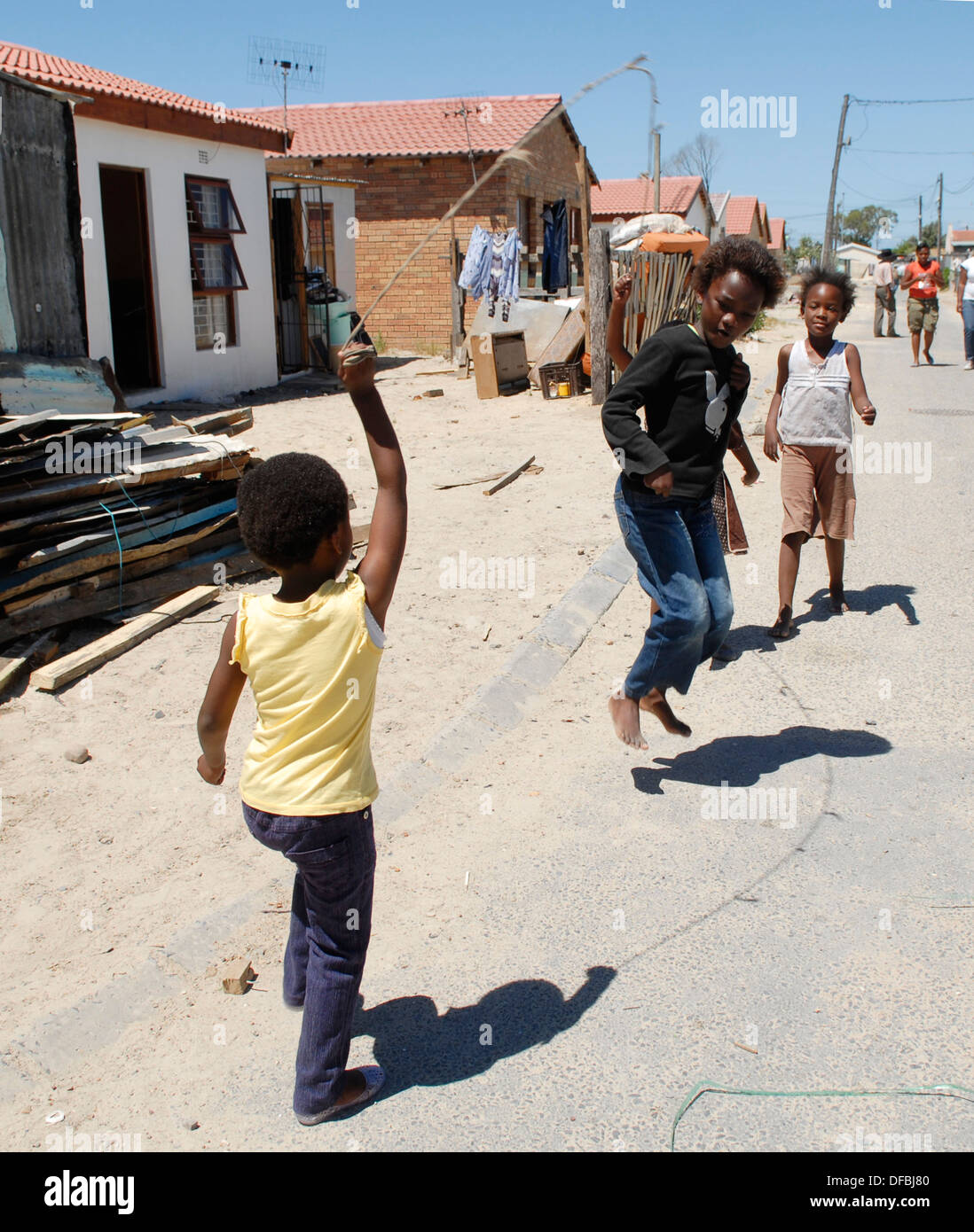 Children play with a skipping rope on the streets of Site C in ...