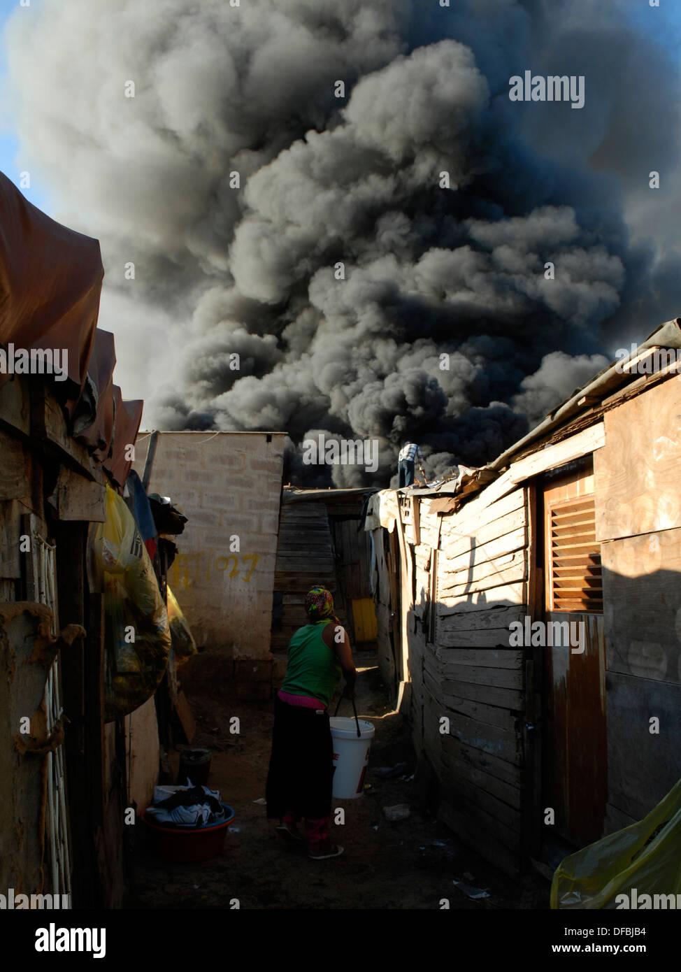 A woman looks on in despair as a shack fire rages out control in ...