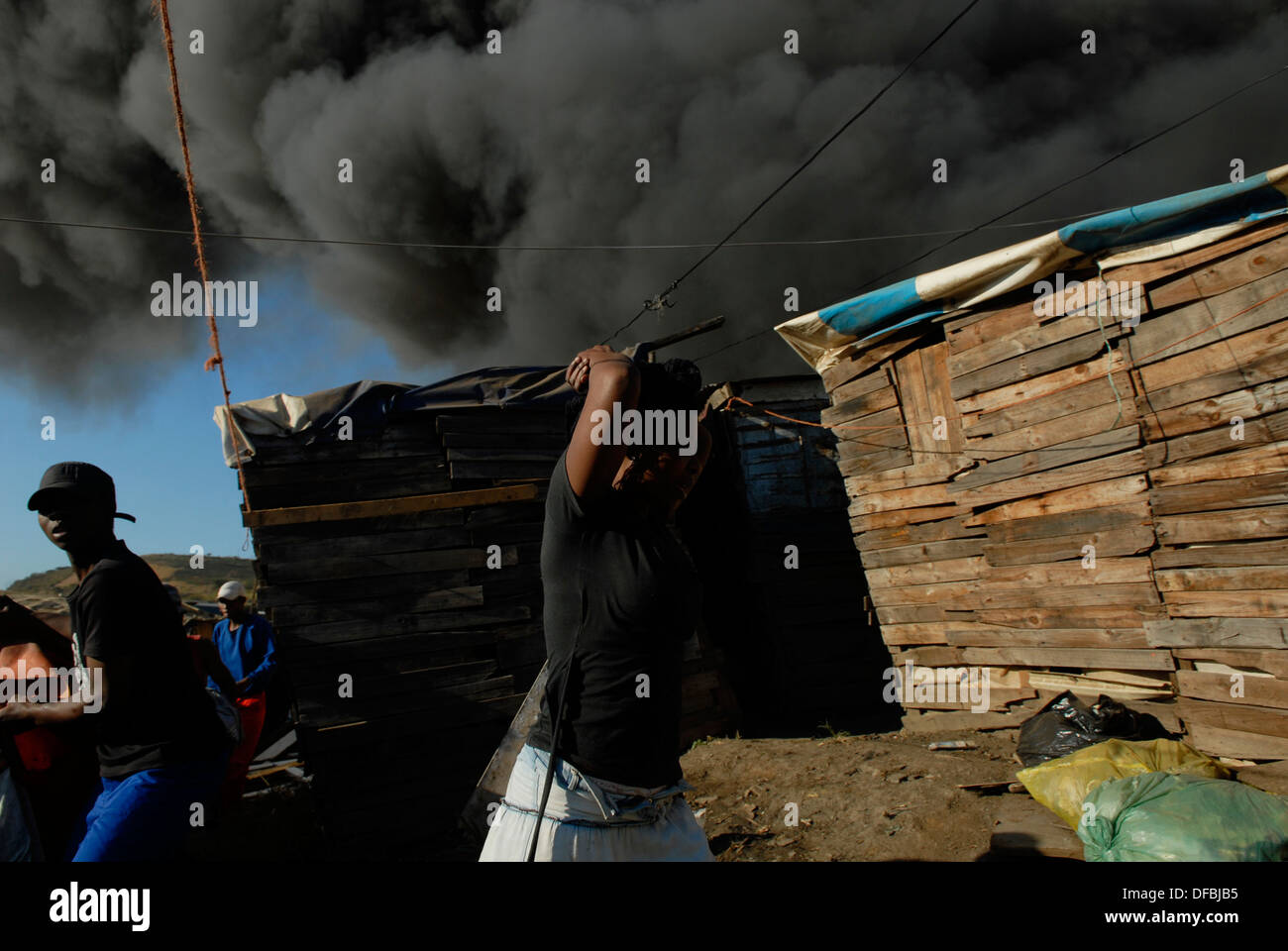A woman holds her head in despair as a shack fire rages out control in ...