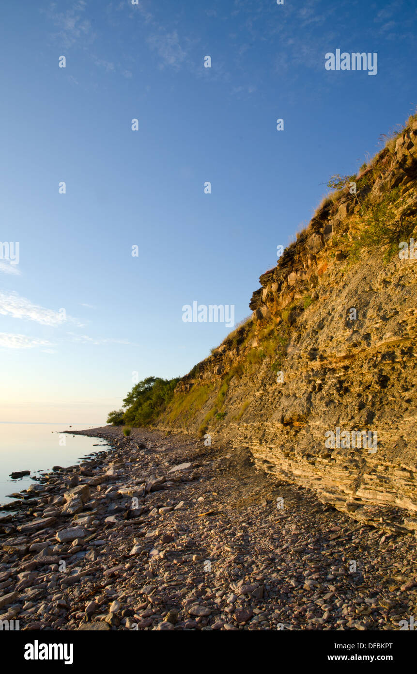 Sunny cliff steep at a stony coast Stock Photo - Alamy