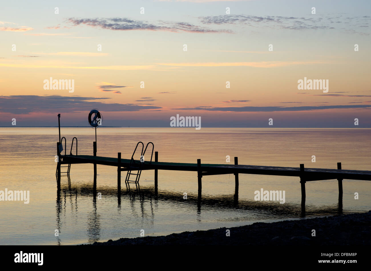 Bath pier with lifebouy in sunset and calm water Stock Photo - Alamy