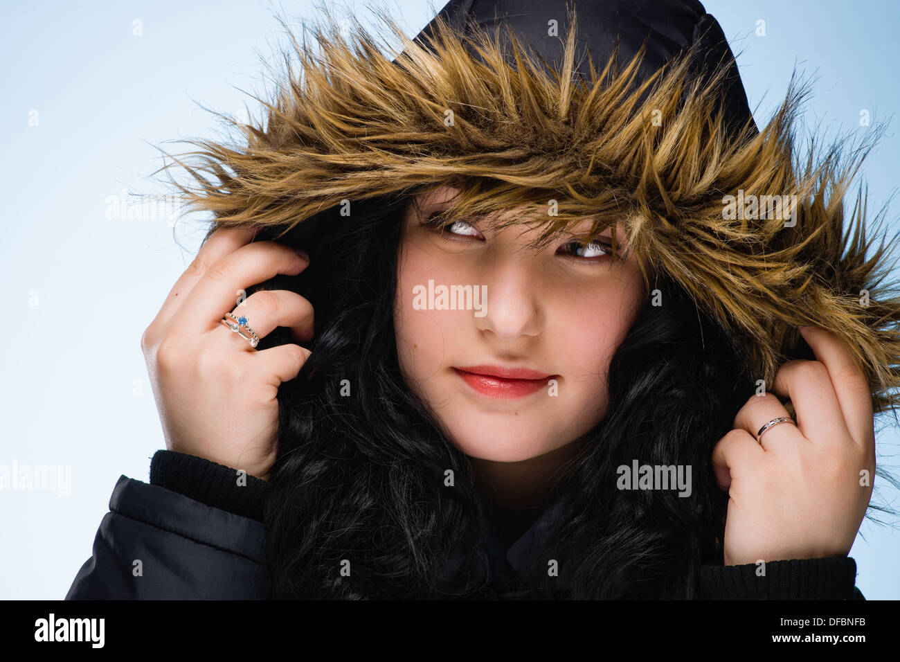 Beautiful girl wearing hood, light blue background, horizon format ...