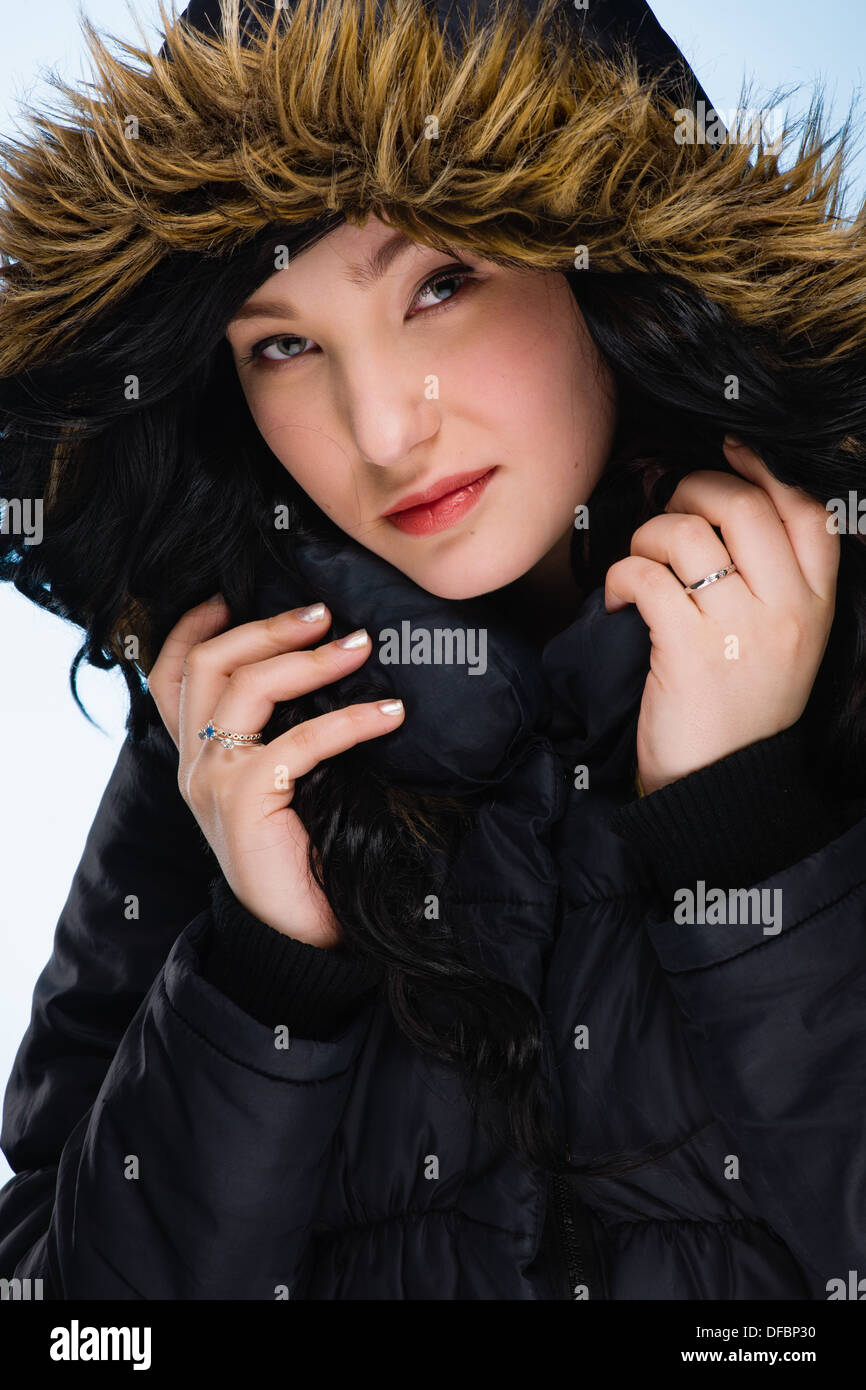 Beautiful girl wearing hood, light blue background, vertical format ...