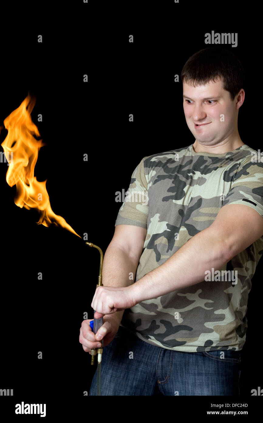 Crazy young man with a gas torch Stock Photo - Alamy