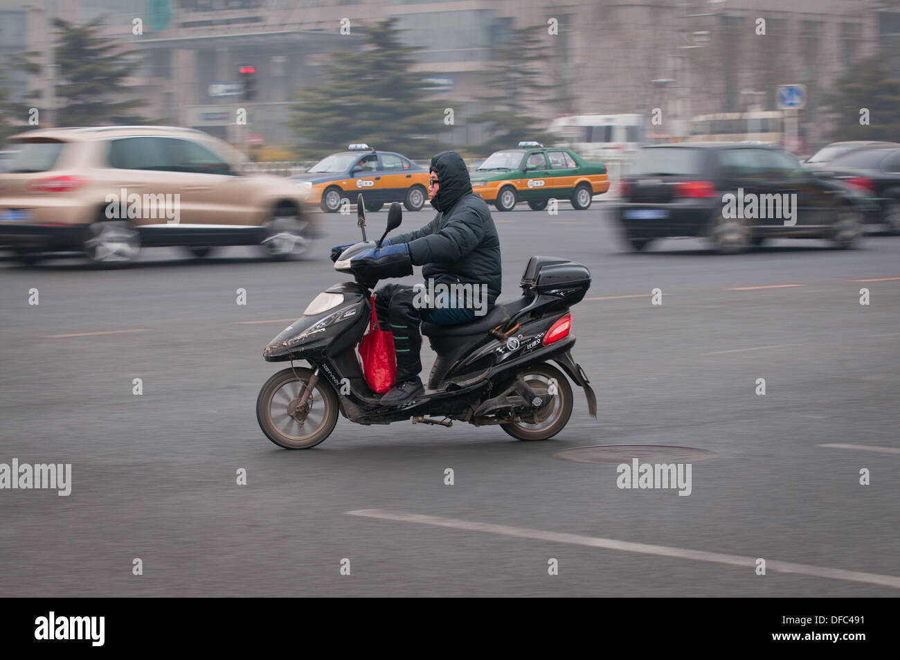 Man riding scooter on street in Beijing, China Stock Photo - Alamy