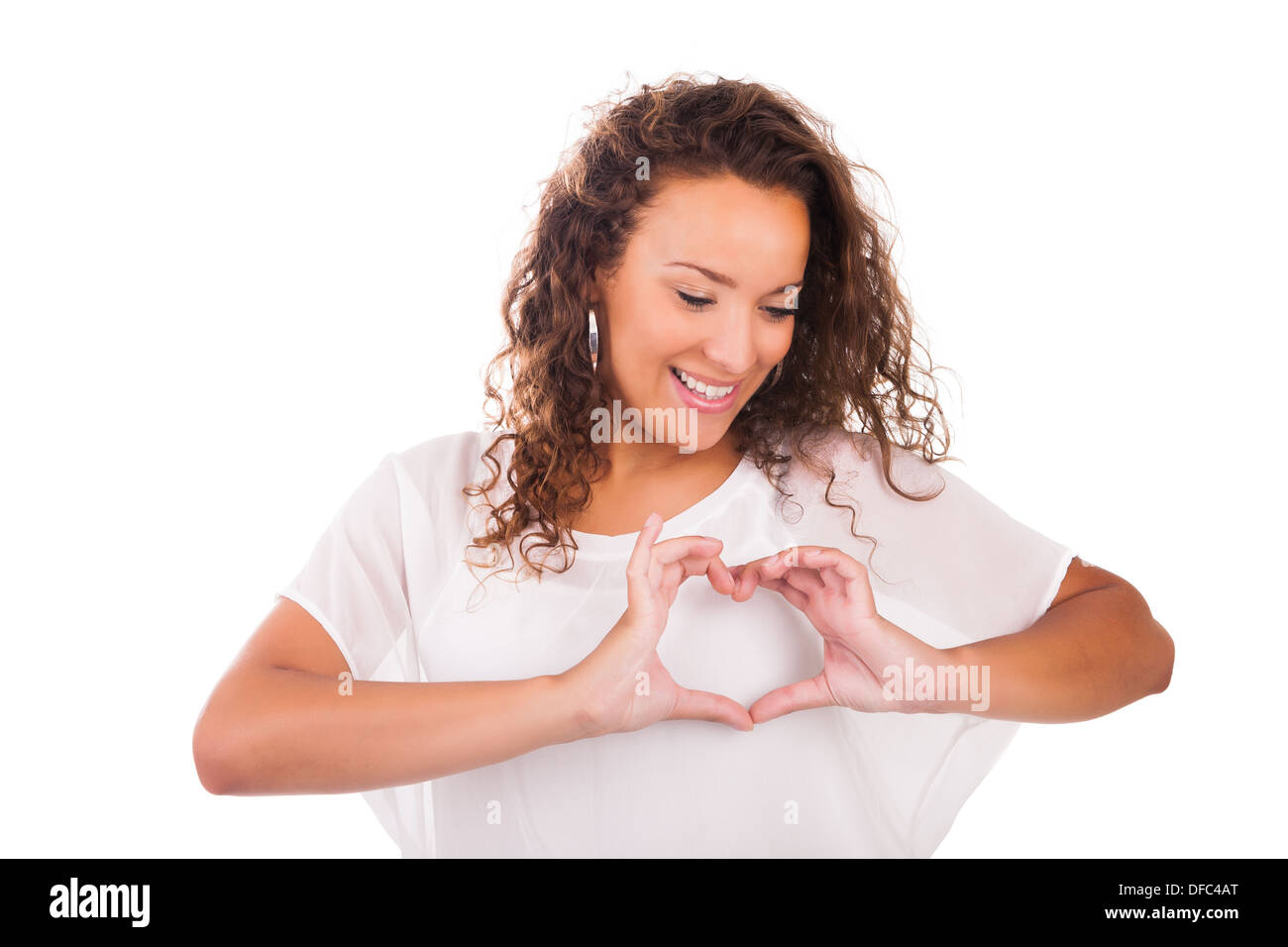 Beautiful young woman making a heart with hands, isolated on white ...