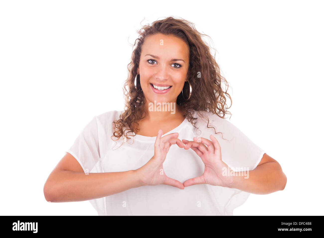 Beautiful young woman making a heart with hands, isolated on white ...