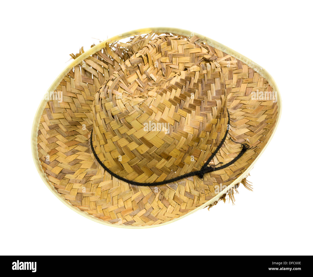 An old woven straw hat that is showing ragged wear on a white ...