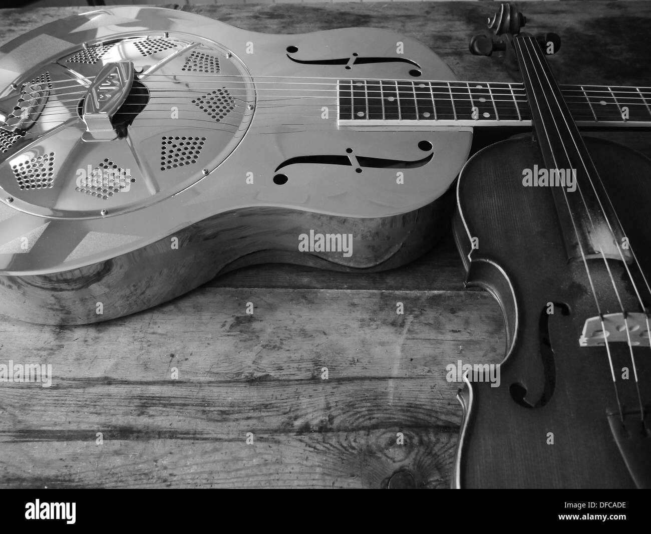 A resonating guitar and a violin/fiddle laying across each other Stock ...