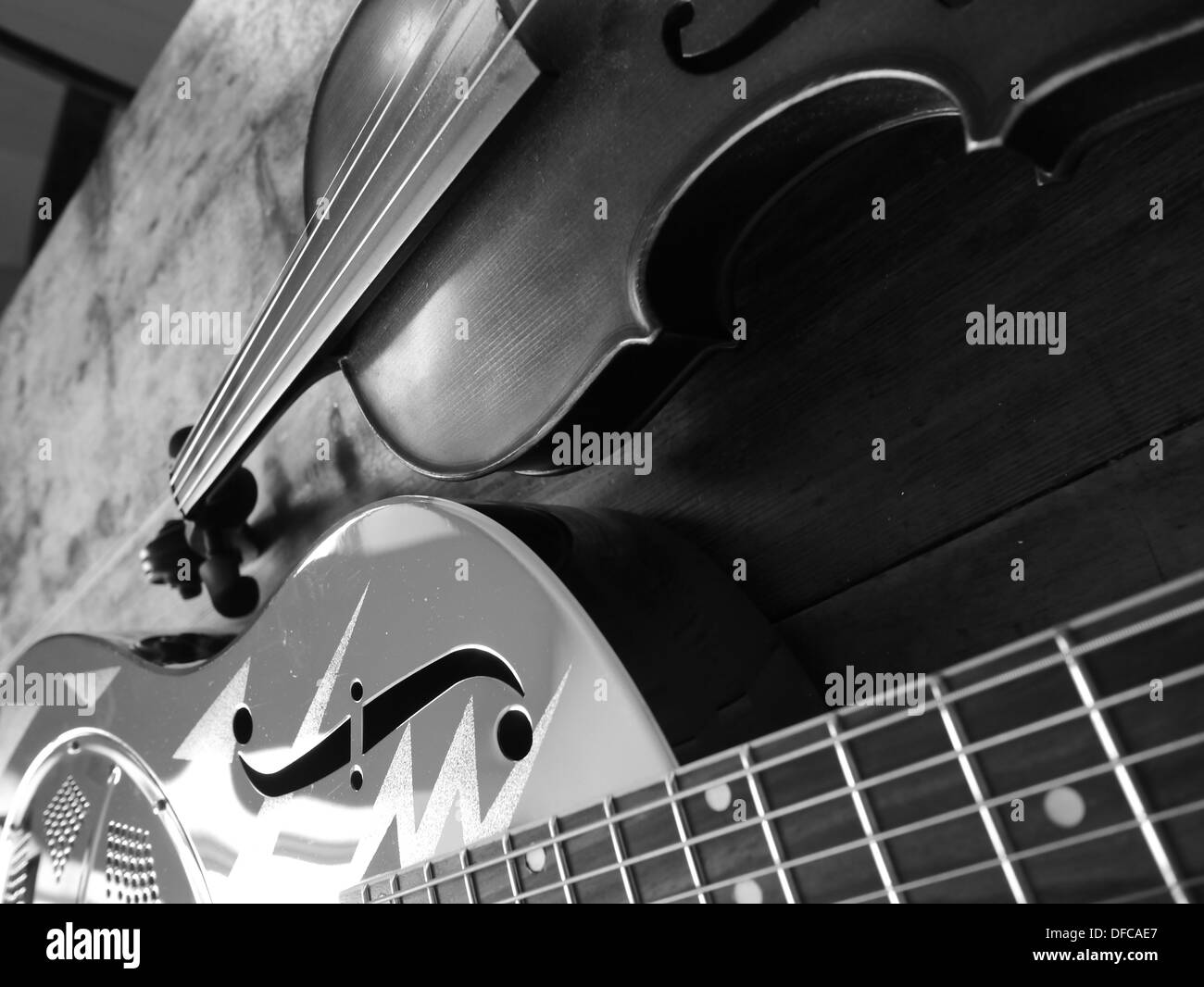 A resonating guitar and a violin/fiddle laying across each other Stock ...