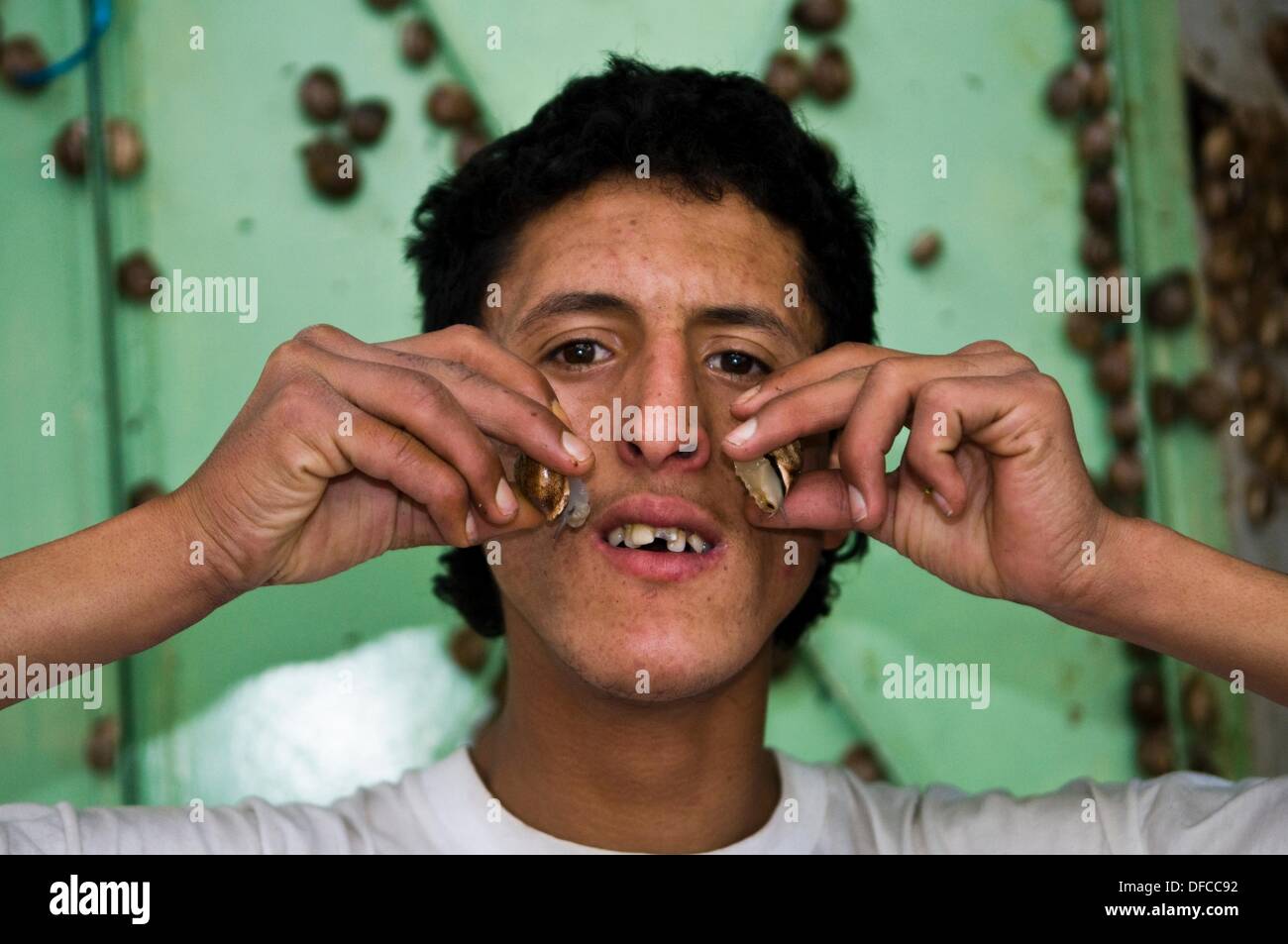 A young Moroccan man holding edible snails in his hands Stock Photo - Alamy