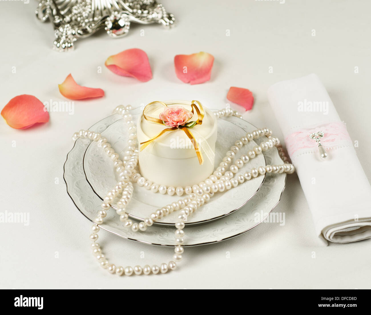 Wedding table accessories with rose petals and pearls Stock Photo - Alamy